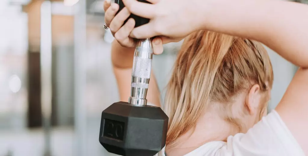 Borst en armen in vorm met slechts een paar dumbbells: een routine die je thuis of in de sportschool kunt doen