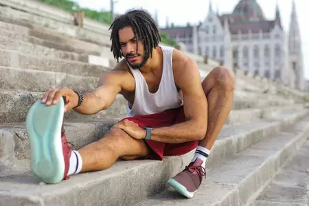 Homme en débardeur blanc assis sur des escaliers en béton 3766217 1