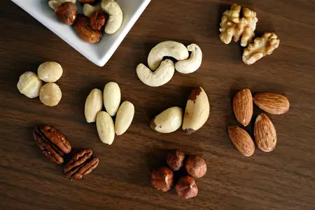 Variety Of Brown Nuts On Brown Wooden Panel High Angle Photo 1295572opt